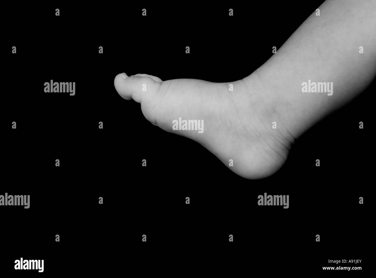 Newborn foot on a black background Stock Photo - Alamy
