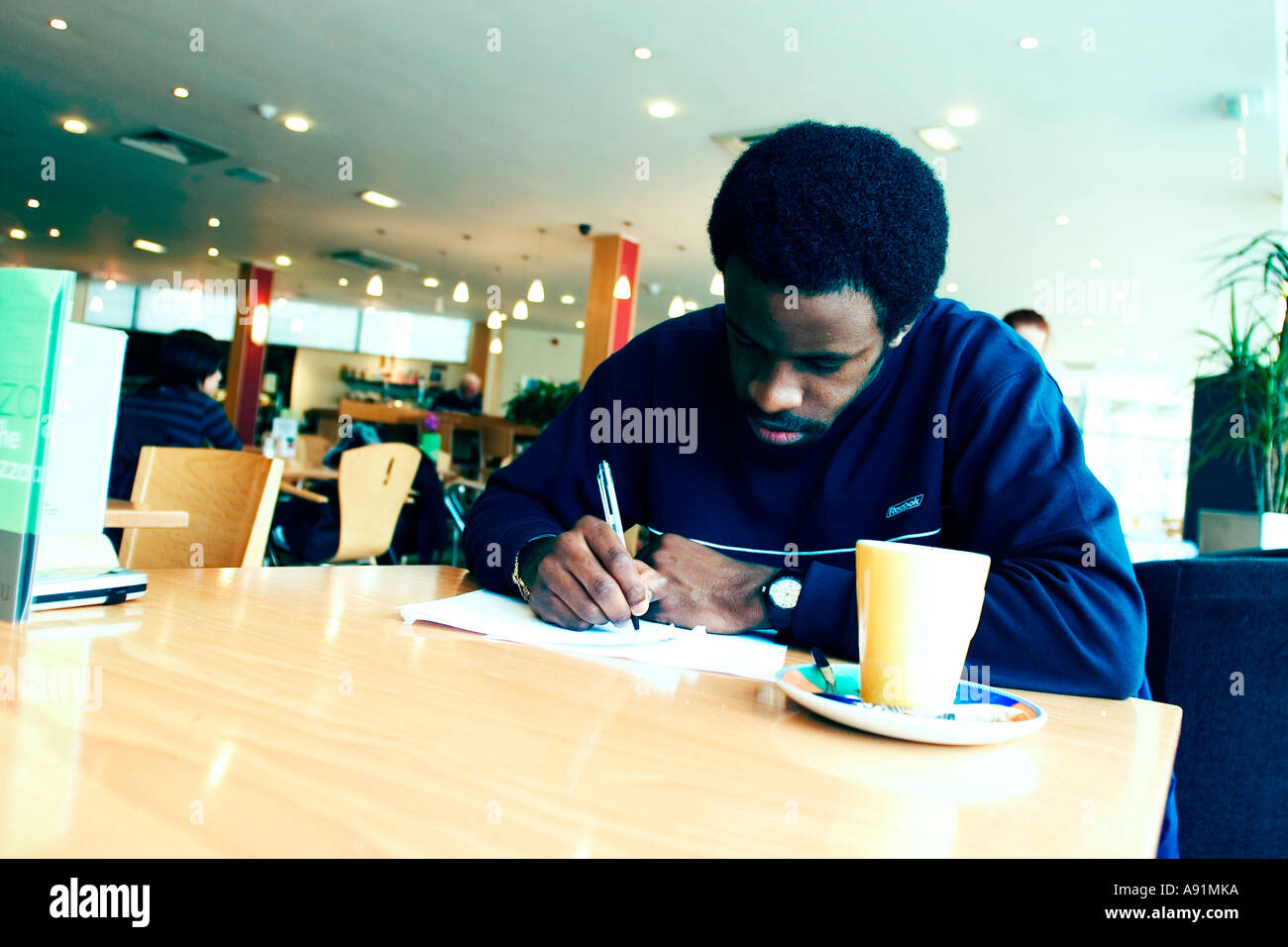 colored male student studying in coffee shop Stock Photo - Alamy
