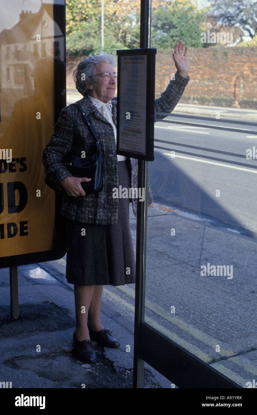 woman hailing a bus at the bus stop Stock Photo - Alamy