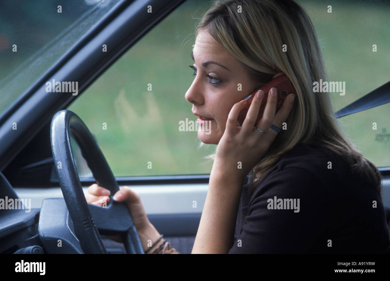 young woman driving and talking on her mobile phone Stock Photo - Alamy