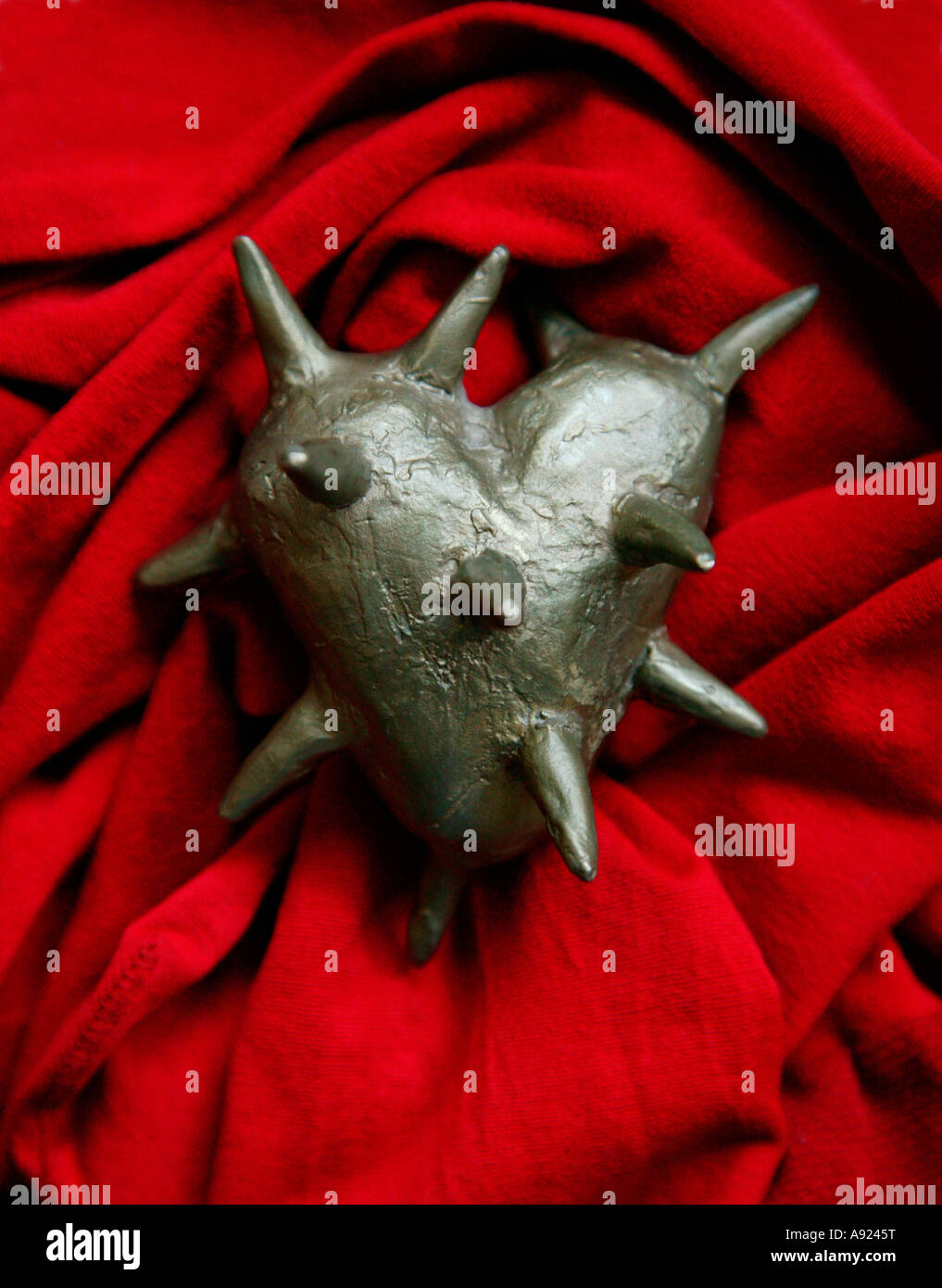 An unusual sculpture of a heart against a red fabric background Stock ...
