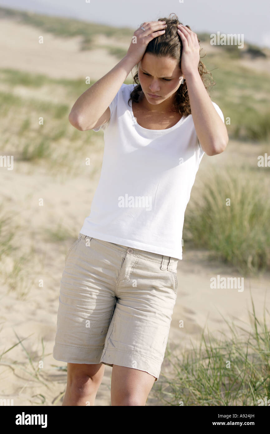 Girl walking on beach stressed Stock Photo - Alamy