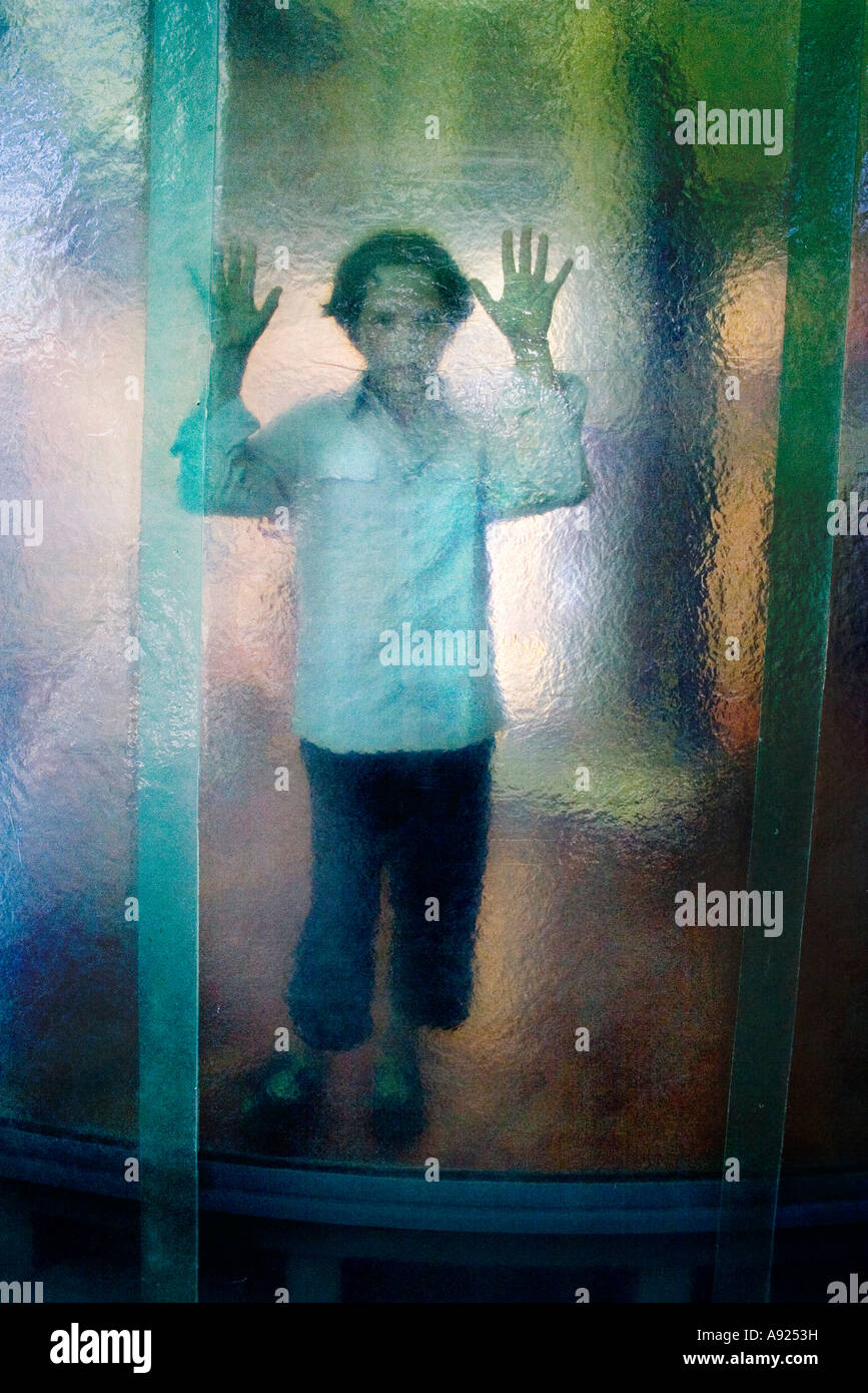 a boy leaning against glass wall Stock Photo - Alamy