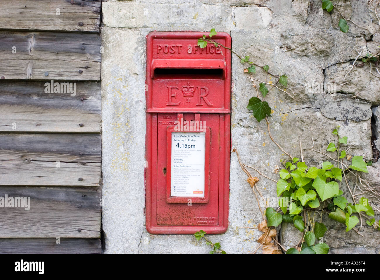 Postbox set in stone wall with timber cladding and ivy Stock Photo - Alamy