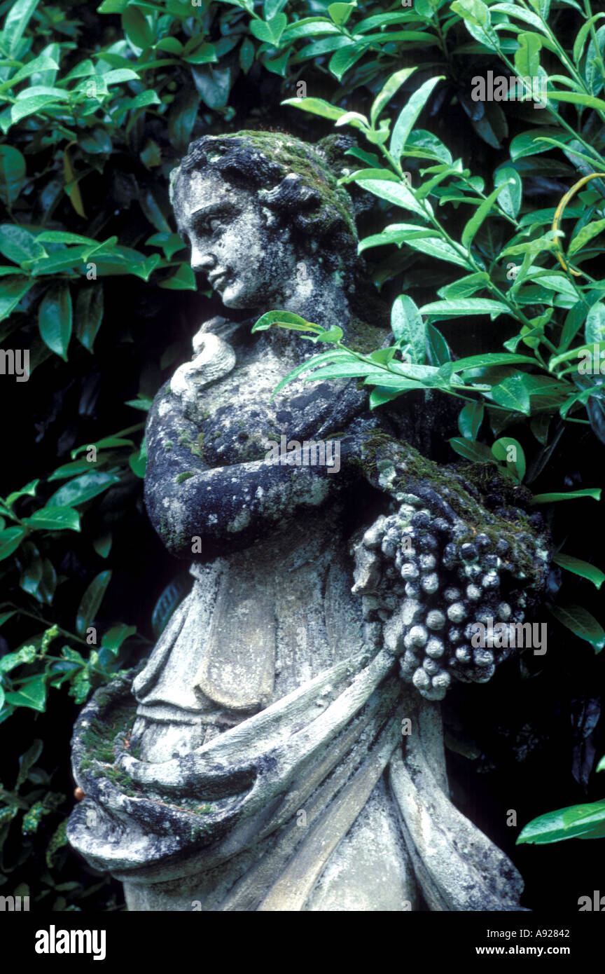statue of girl with berries under tree, worn stone, old, beautiful girl ...