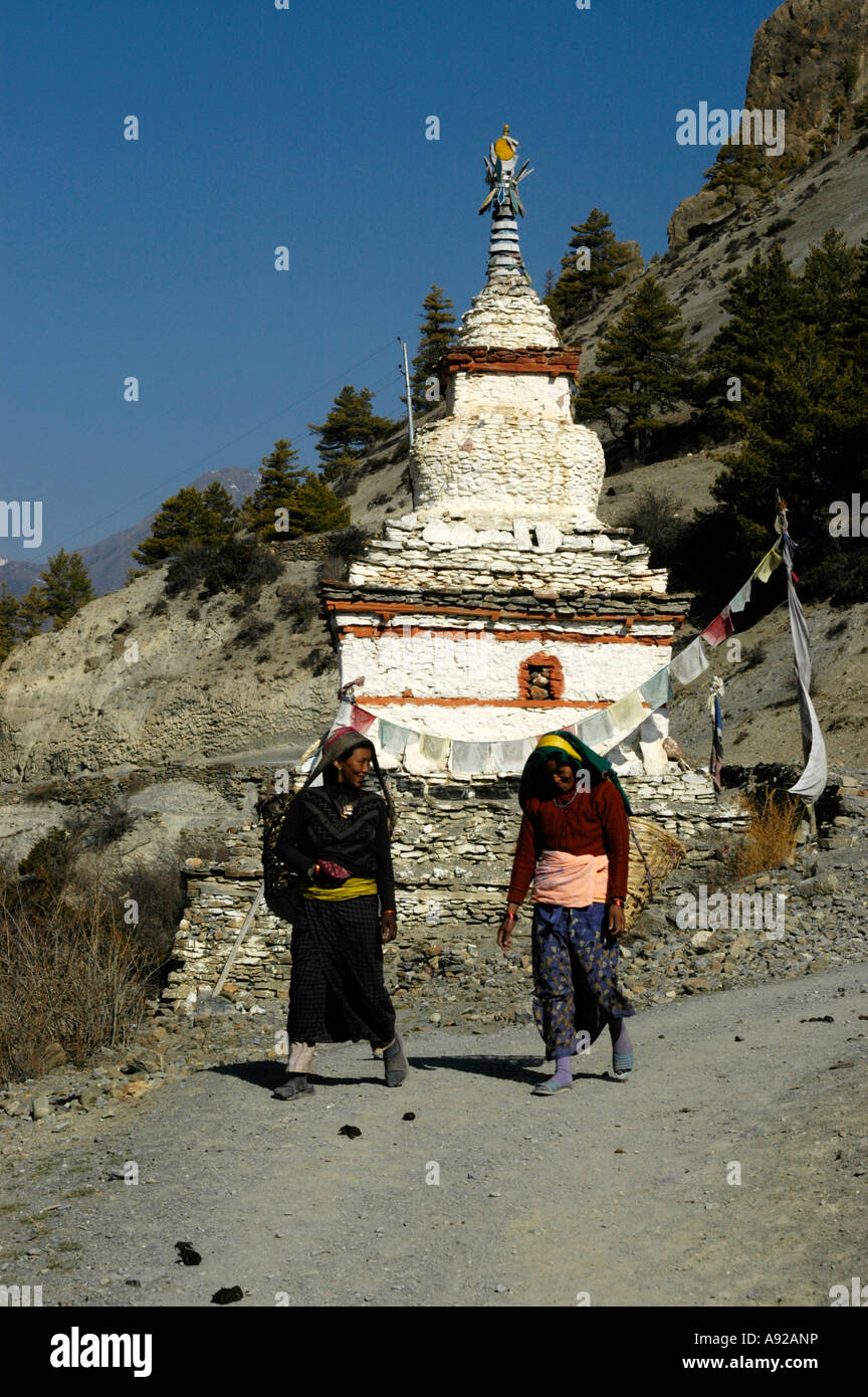 Two women walk by a white stupa Mungji Annapurna Region Nepal Stock ...
