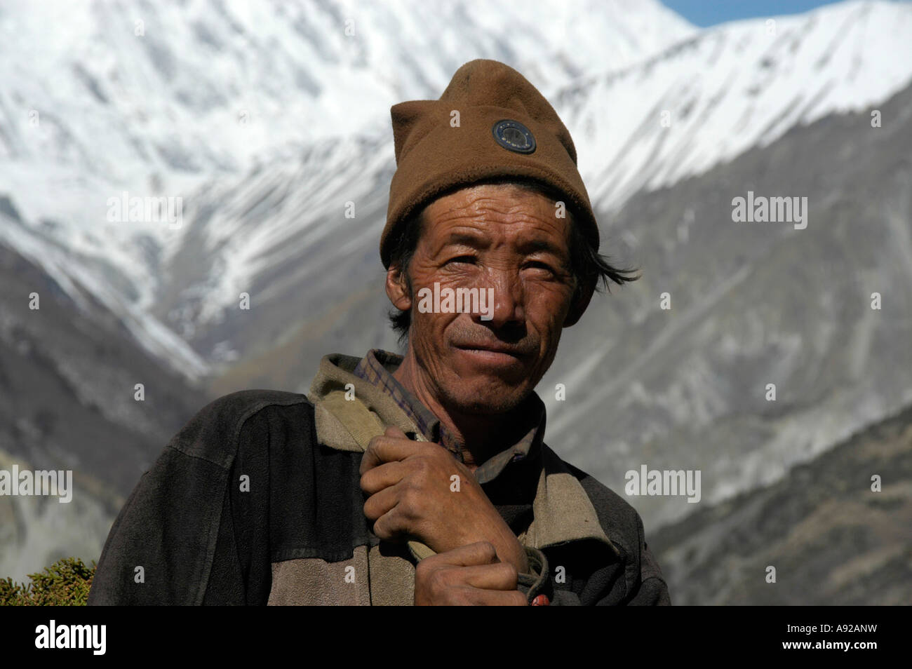 Portrait man wearing a cap and ice-capped mountains in the background ...