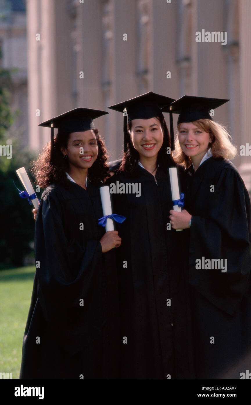 Three young women wearing graduation gowns and holding diplomas Stock ...