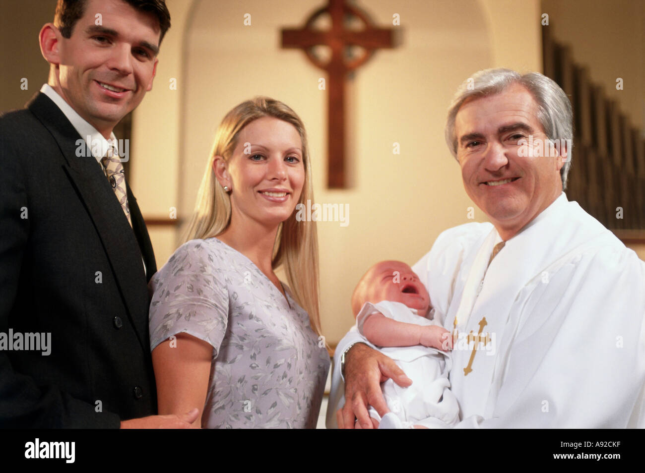 Close-up of parents with their son at a baptism Stock Photo - Alamy