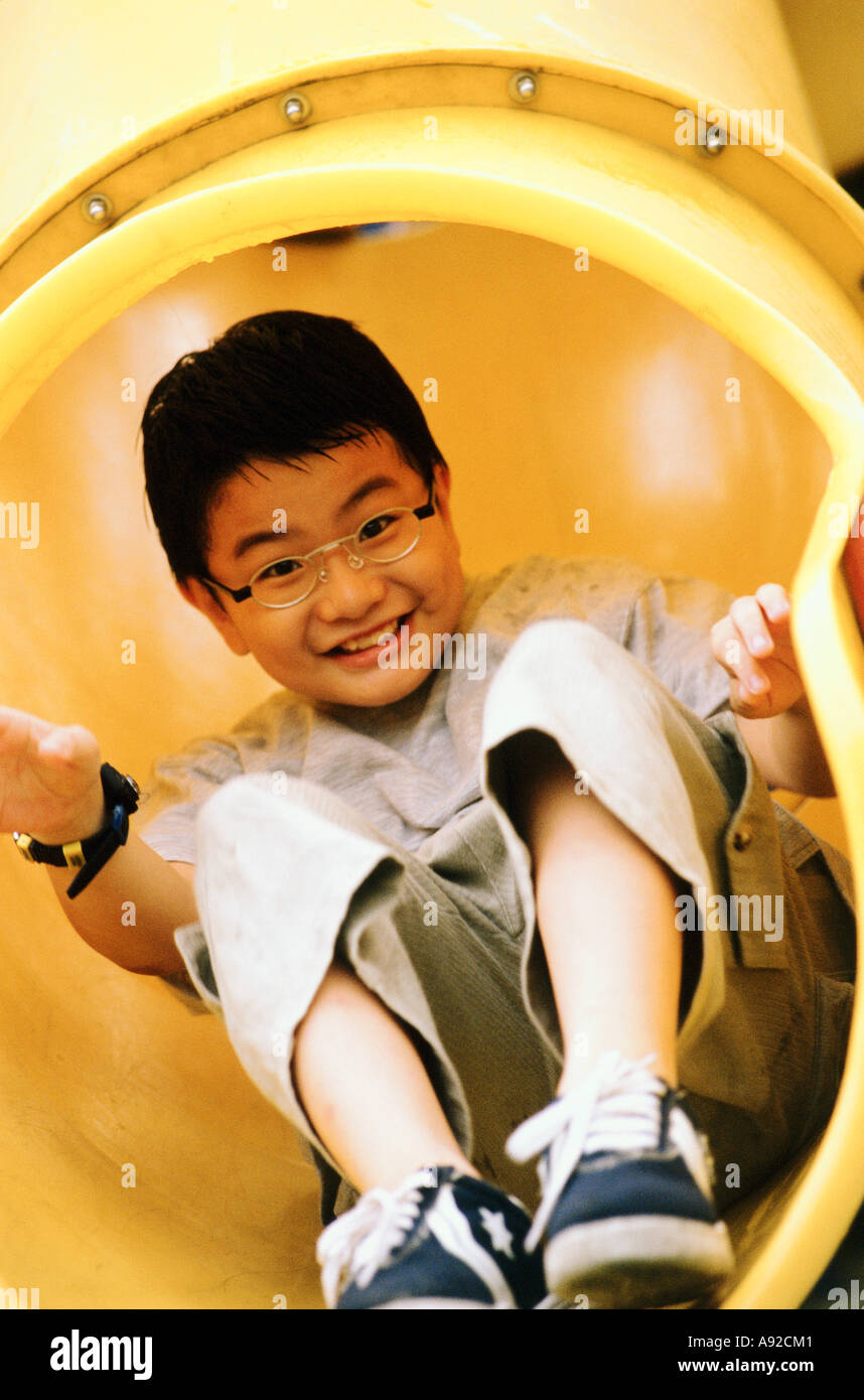 Close-up of a boy sliding down a slide Stock Photo - Alamy