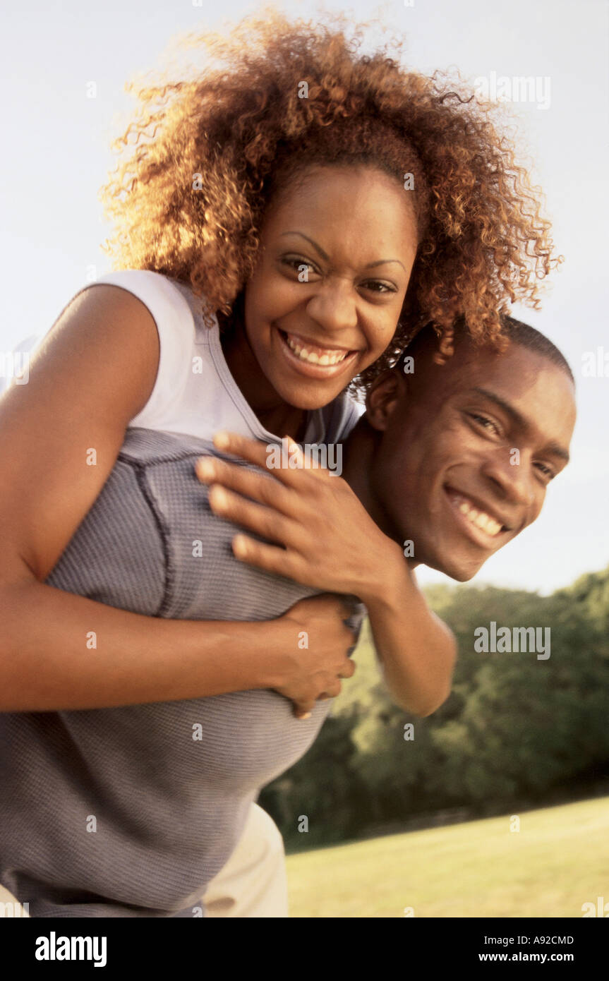 Young woman riding piggyback on a young man Stock Photo - Alamy
