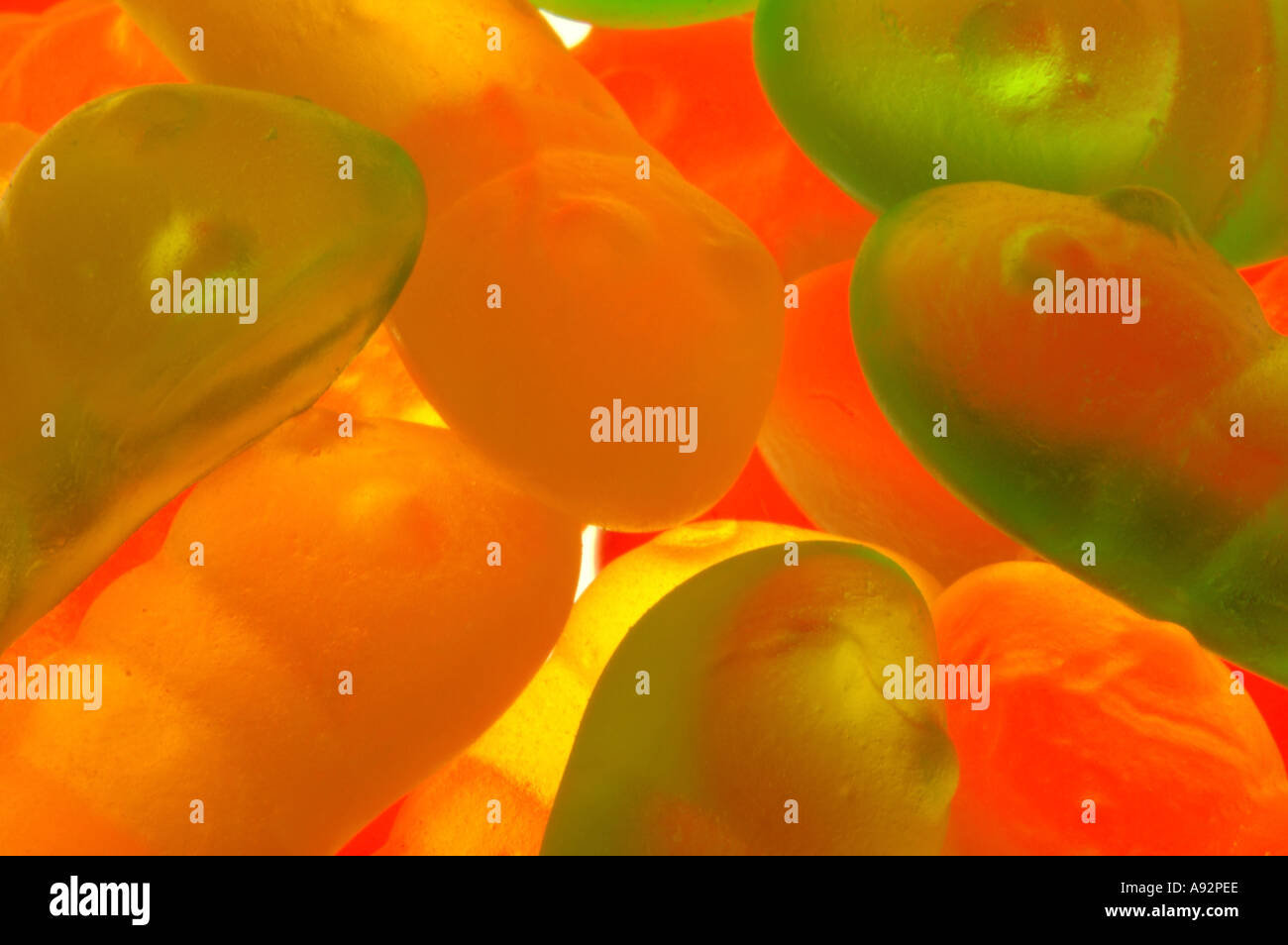 close up of red green and yellow jelly worm sweets lit from below Stock ...