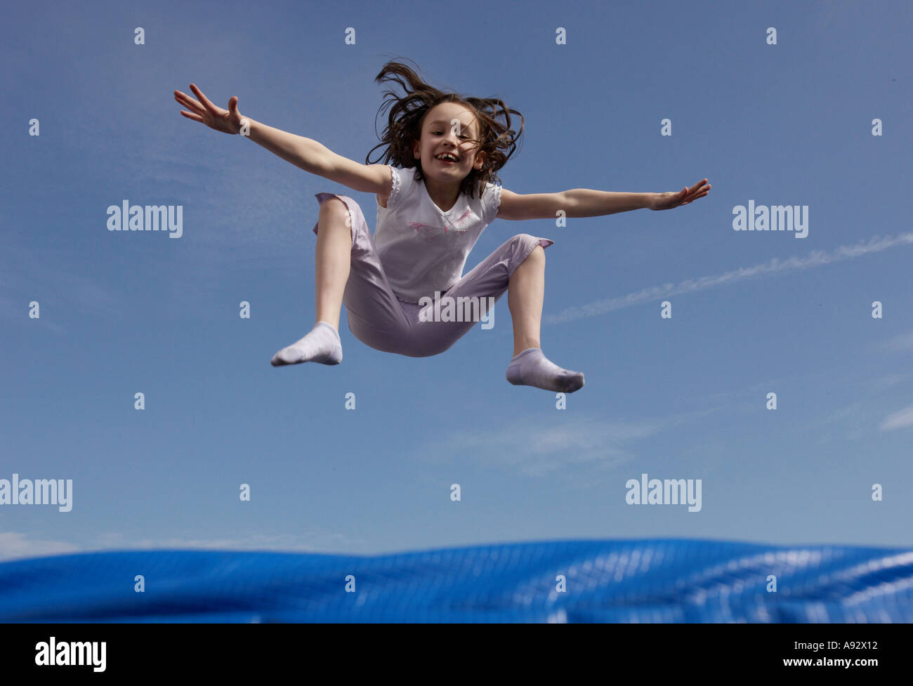 young girl bouncing on trampoline Stock Photo - Alamy