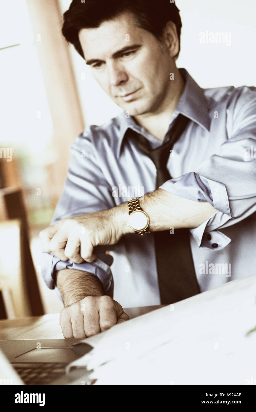 Late 40s Caucasian male businessman rolling up sleeves Stock Photo - Alamy
