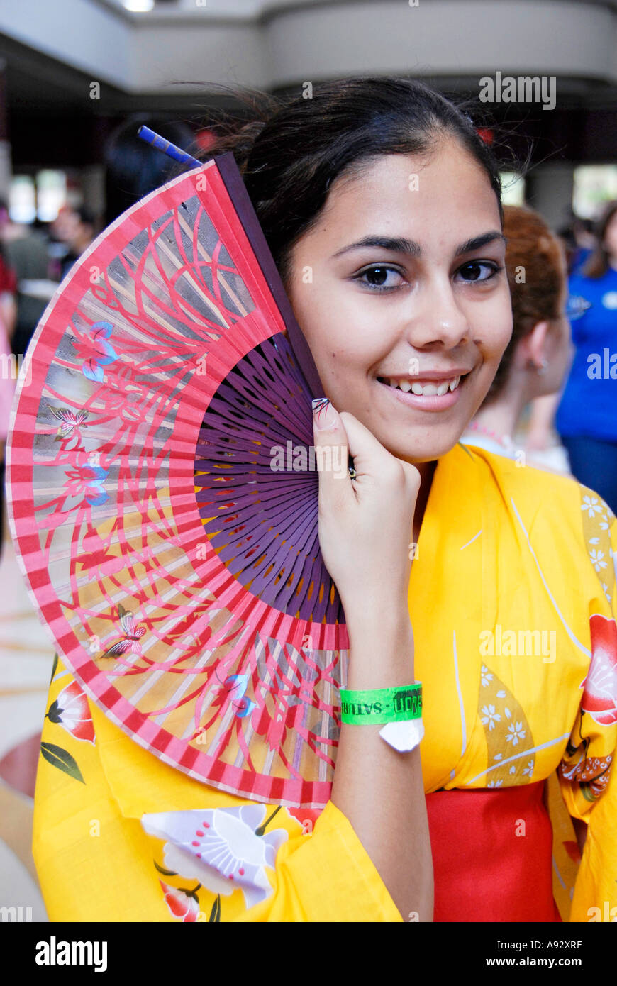 Beautiful young woman with fan next to her face Stock Photo - Alamy