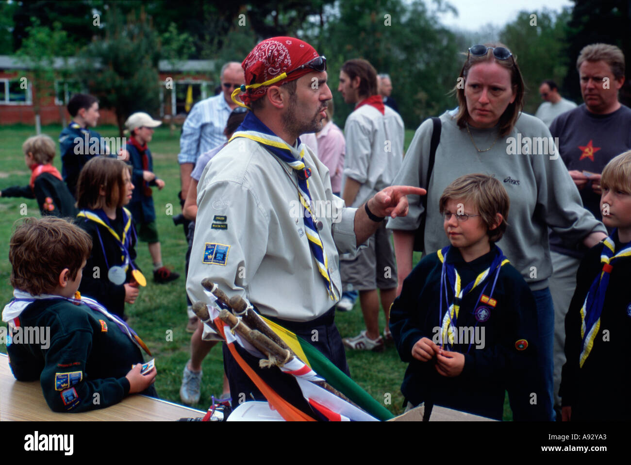 Scoutmaster at camp instructs scouts nr London England uk britain ...