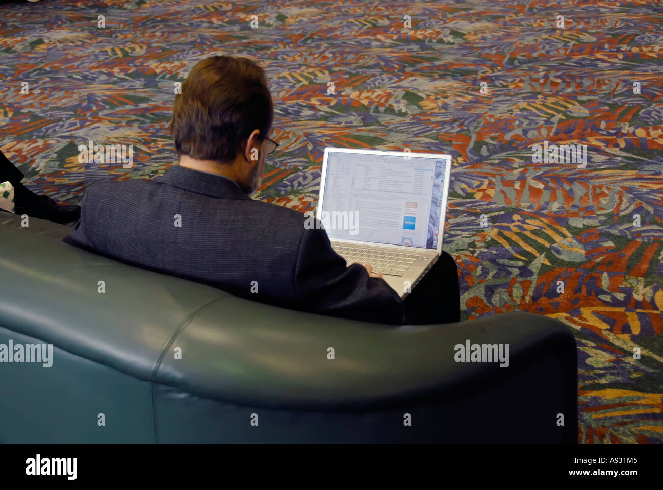 Adult businessman professional works on wireless laptop computer while ...