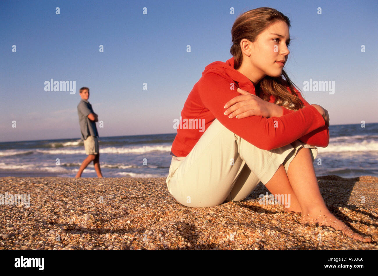 Side profile of a teenage girl sitting on the beach Stock Photo - Alamy