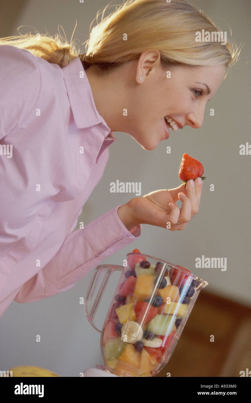 Side profile of a young woman eating a strawberry Stock Photo - Alamy