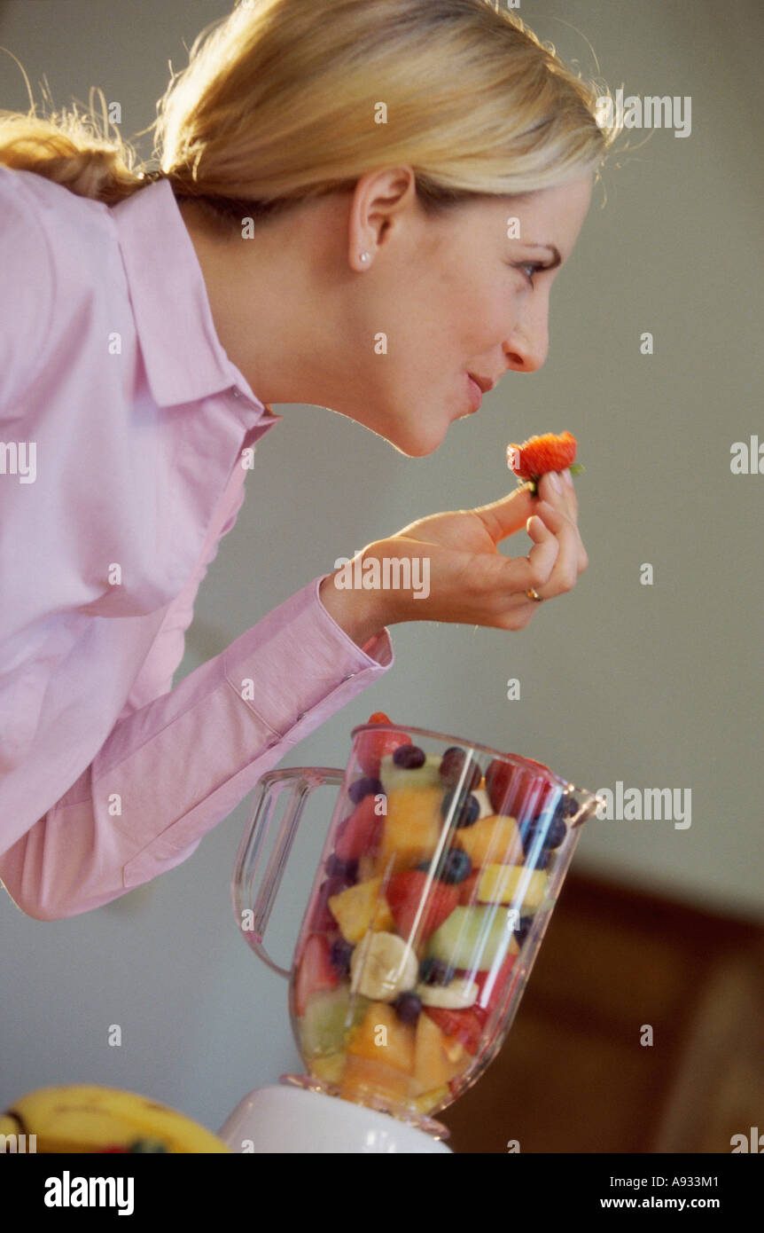 Side profile of a young woman eating a strawberry Stock Photo - Alamy