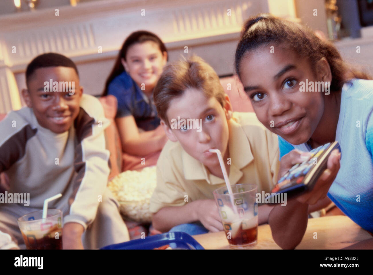 Portrait of two teenage girls and two teenage boys watching television ...