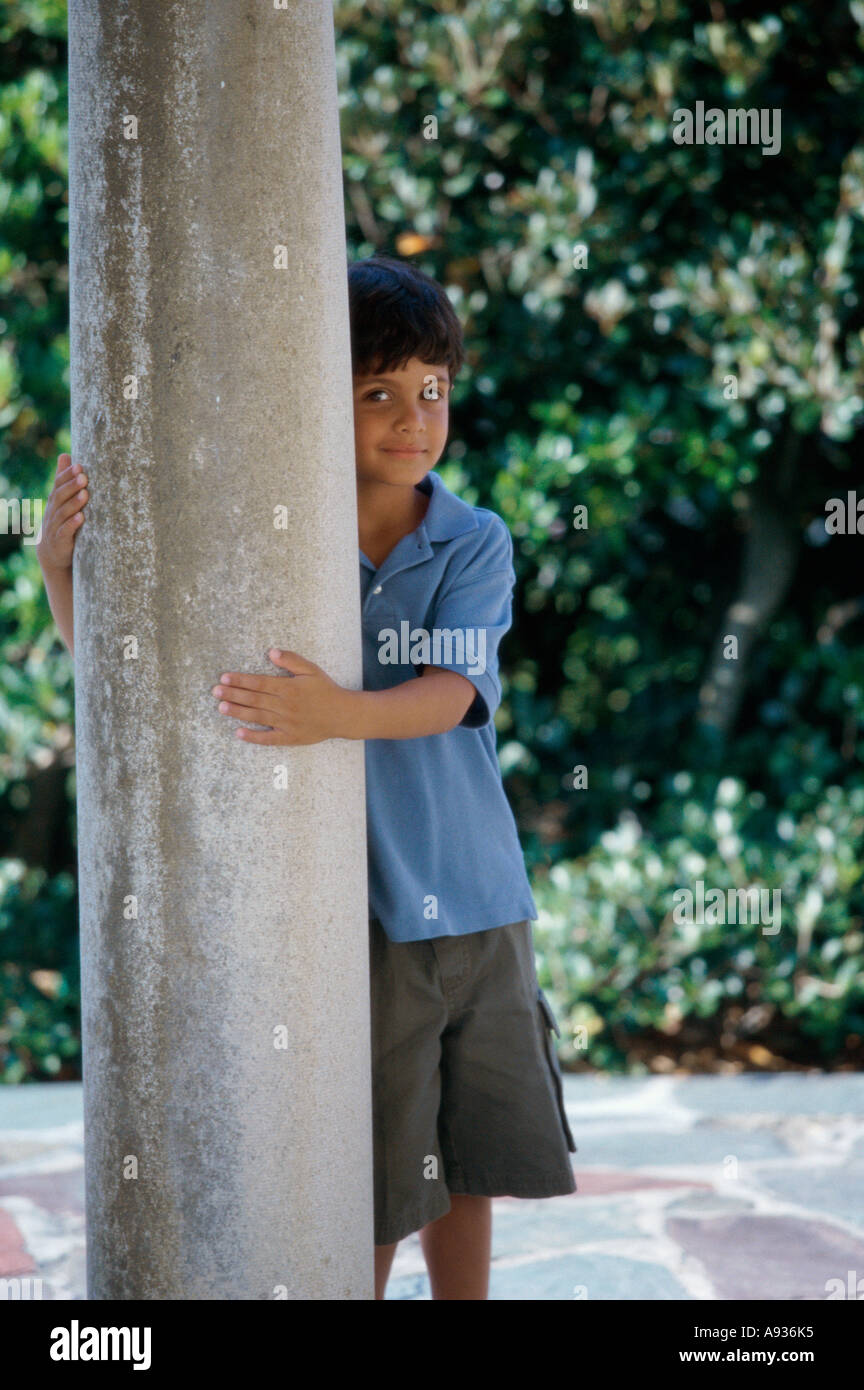 Portrait of a boy standing behind a column Stock Photo - Alamy