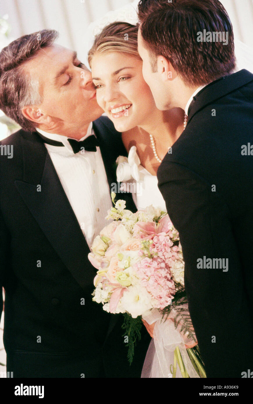 Father and groom kissing the bride Stock Photo - Alamy