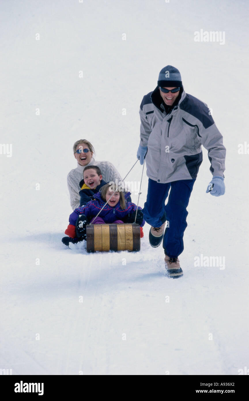 Father pulling his family on a sled Stock Photo - Alamy