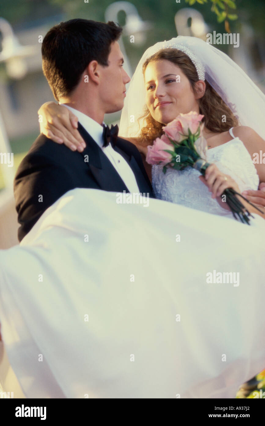 Groom carrying his bride Stock Photo - Alamy