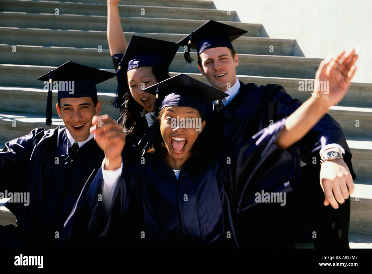 Four young graduates smiling Stock Photo - Alamy