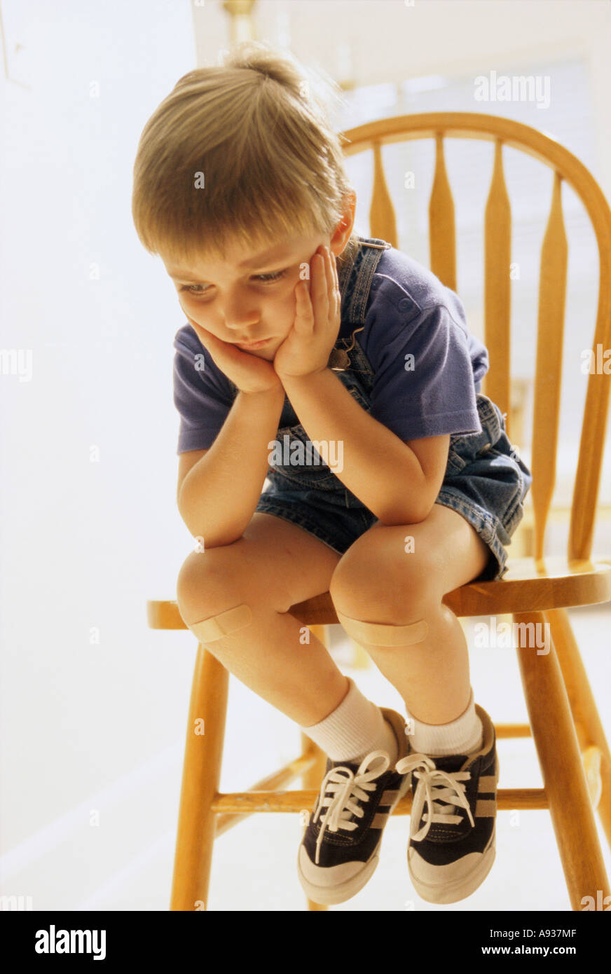 Close-up of a boy sitting on a chair Stock Photo - Alamy