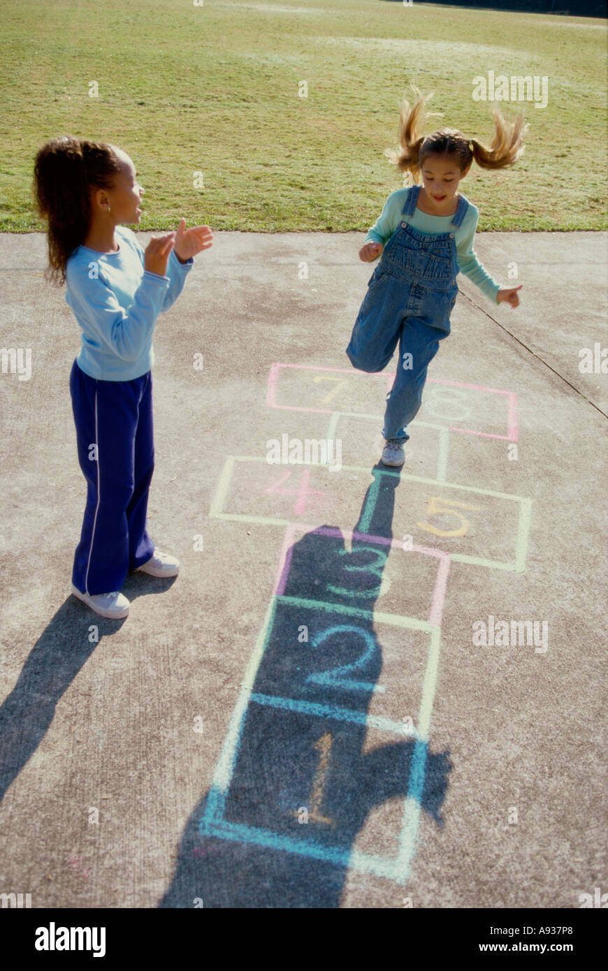 High angle view of two girls playing hopscotch Stock Photo - Alamy