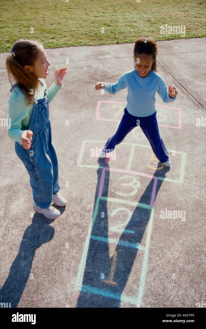 High angle view of two girls playing hopscotch Stock Photo - Alamy