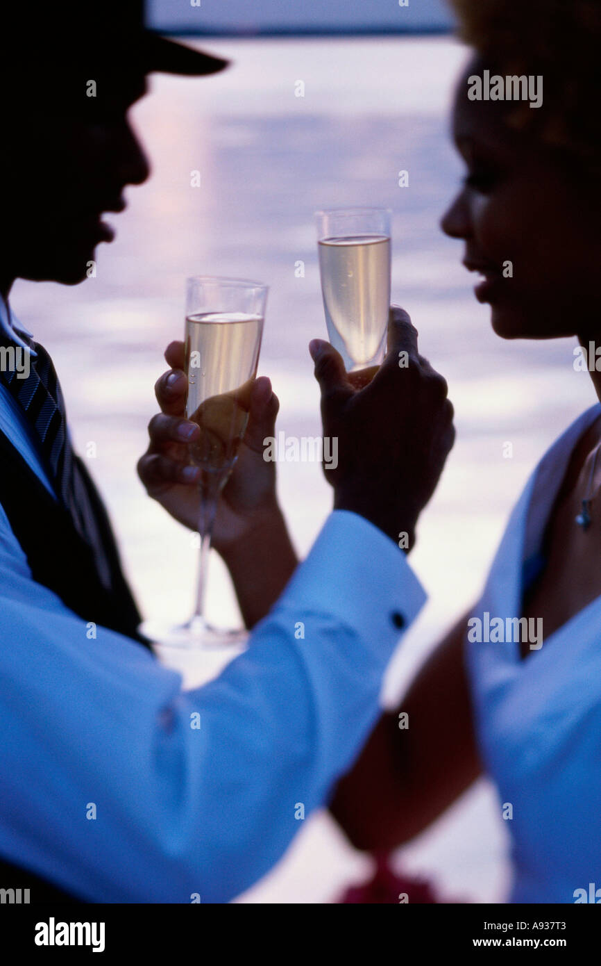 Side profile of a newlywed couple holding champagne flutes Stock Photo ...
