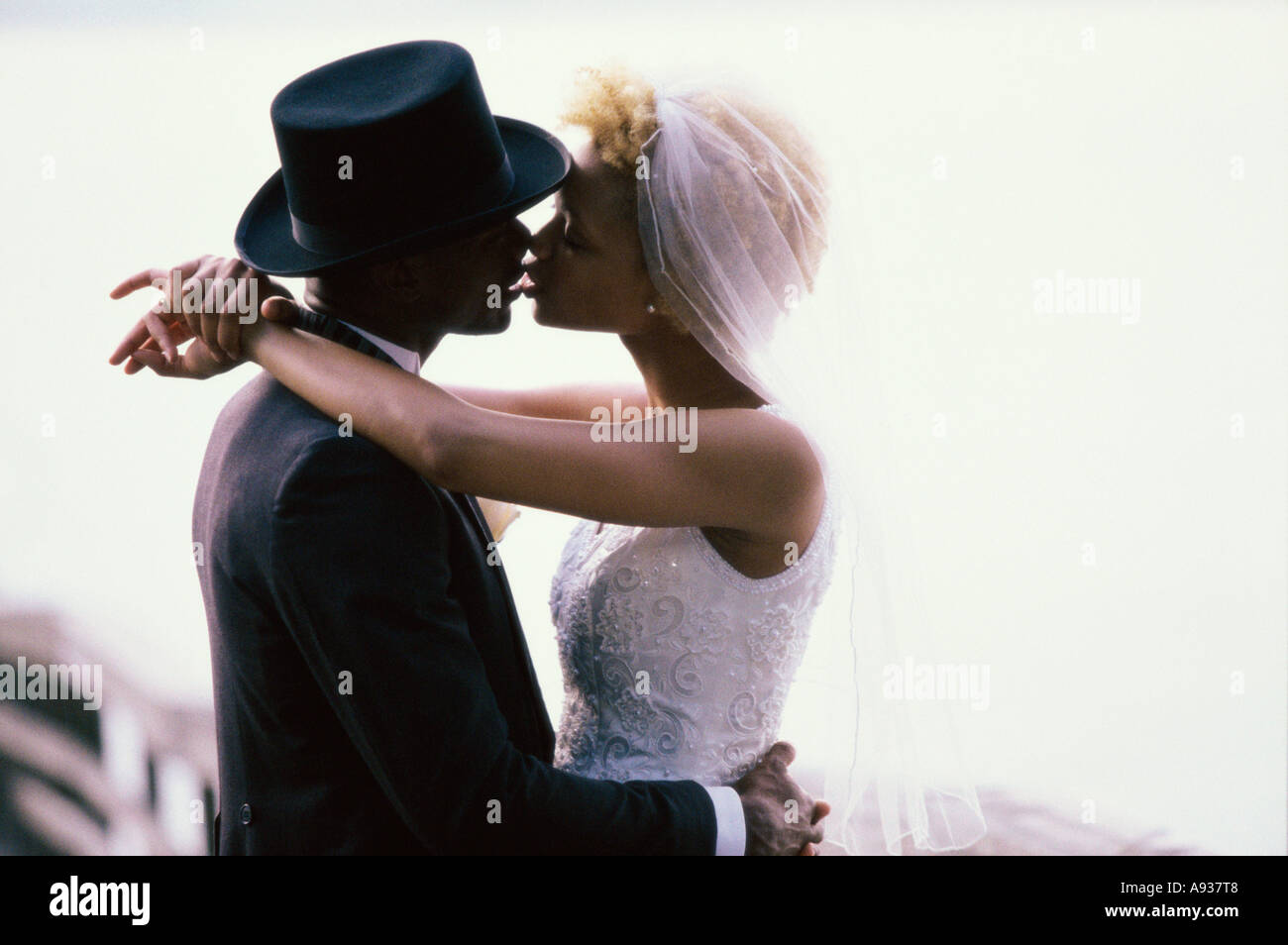 Side profile of a newlywed couple kissing each other Stock Photo - Alamy