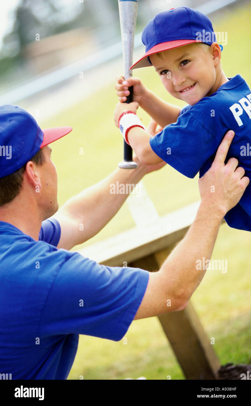 Side profile of a coach teaching a boy to play baseball Stock Photo - Alamy