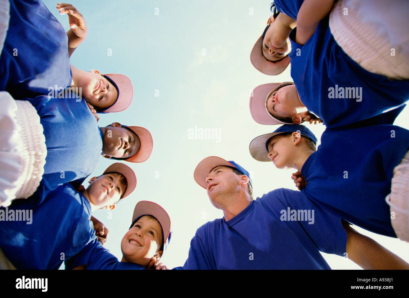 Low angle view of baseball players standing in a huddle with their ...