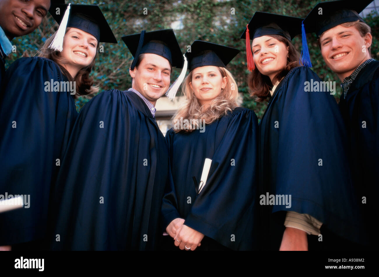 Low angle view of five young graduates smiling Stock Photo - Alamy