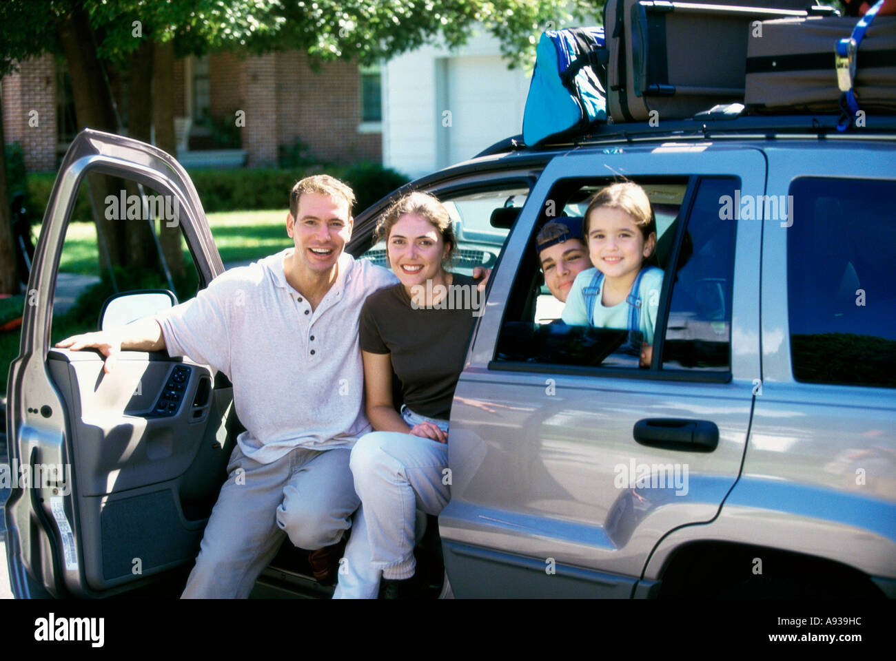 Portrait of parents with their son and daughter sitting in a car Stock ...