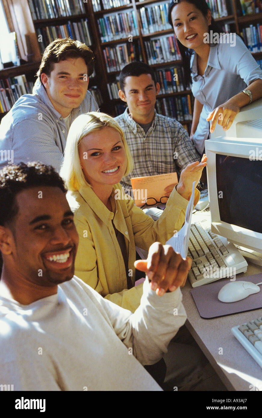 Five college students in a library smiling Stock Photo - Alamy