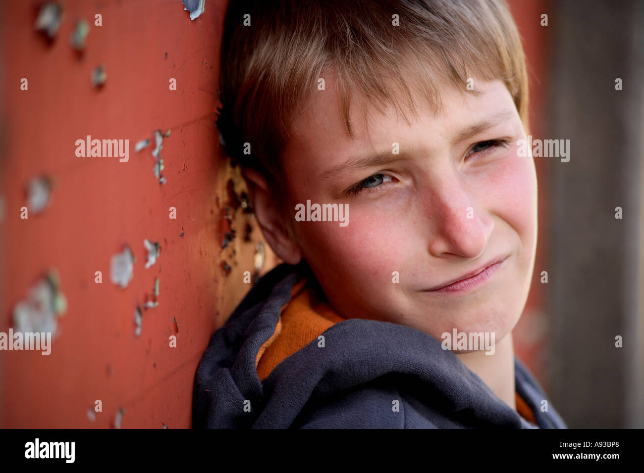 Horizontal close up portrait of young teenage lad alone, leaning on ...