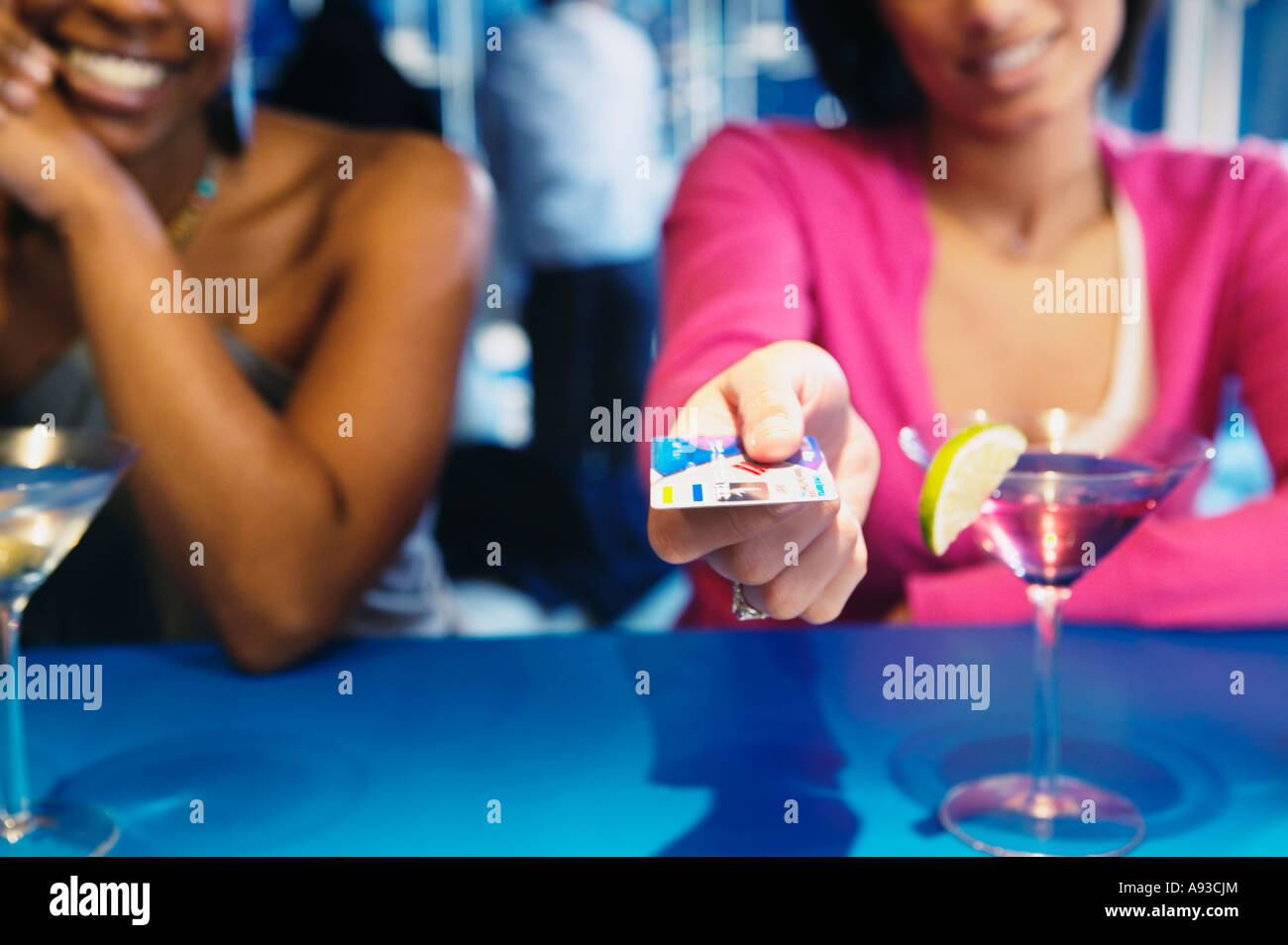 African woman handing credit card over bar Stock Photo - Alamy
