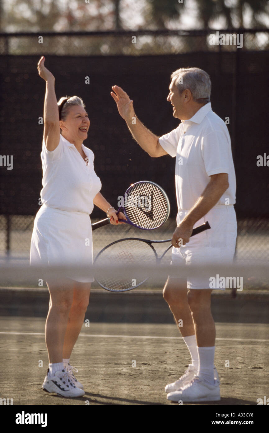 Side profile of a senior couple giving high-five to each other Stock ...