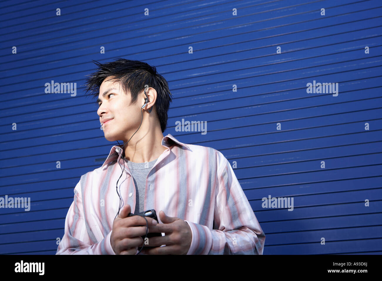 Pacific Islander man listening to mp3 player Stock Photo - Alamy