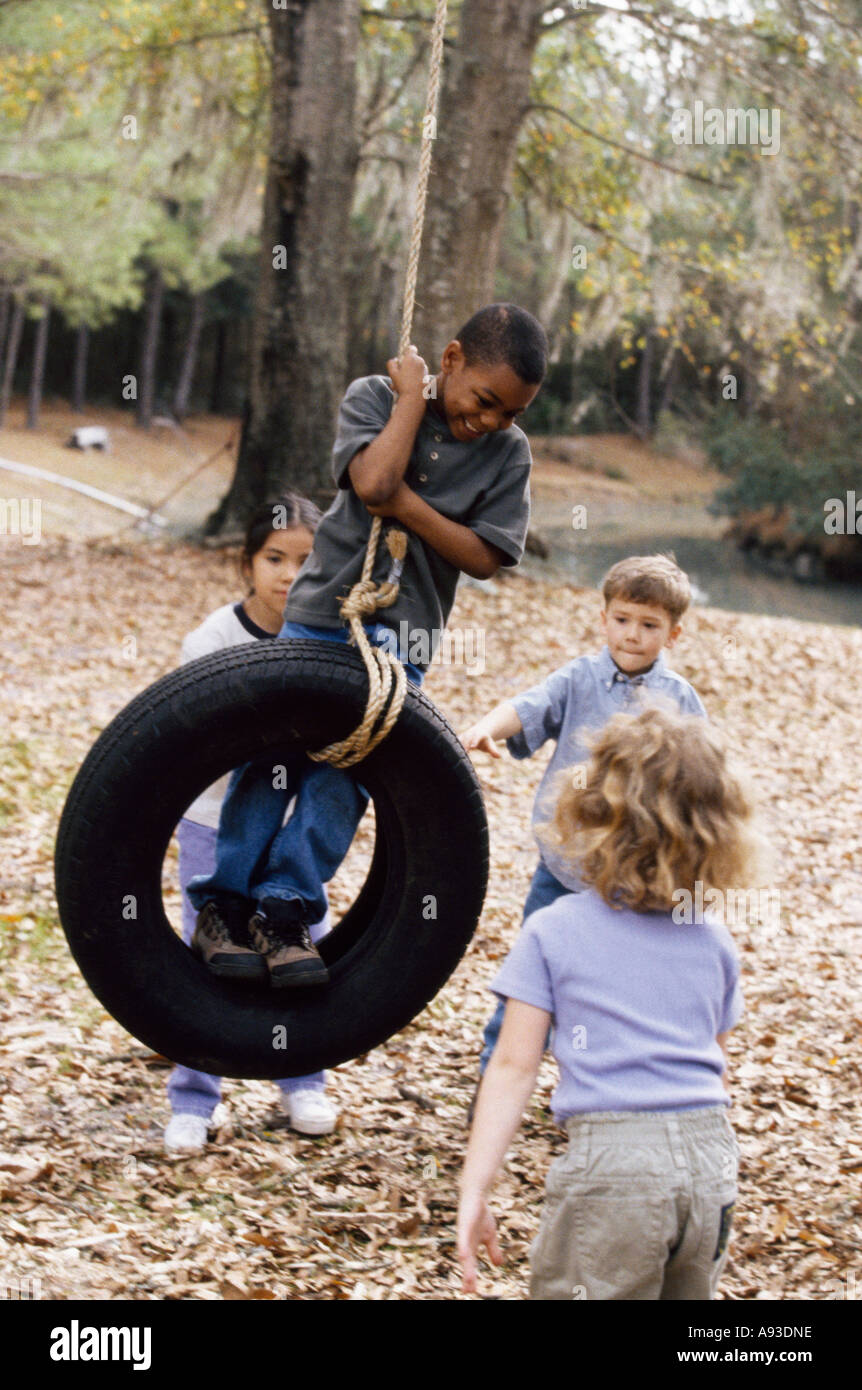 Boys pushing girls on tire swing hi-res stock photography and images ...