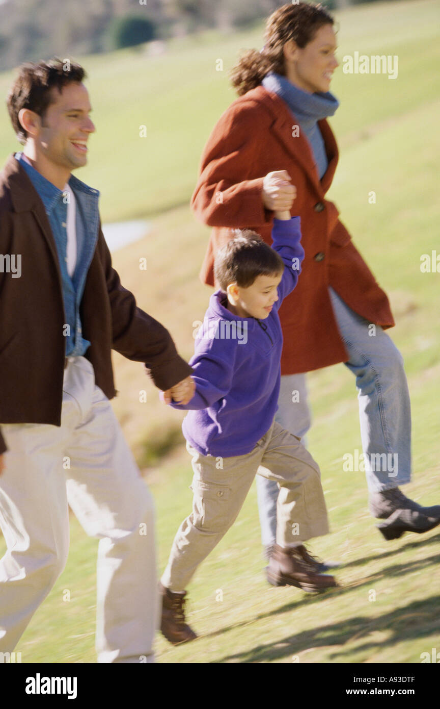 Parents running with their son in a park Stock Photo - Alamy