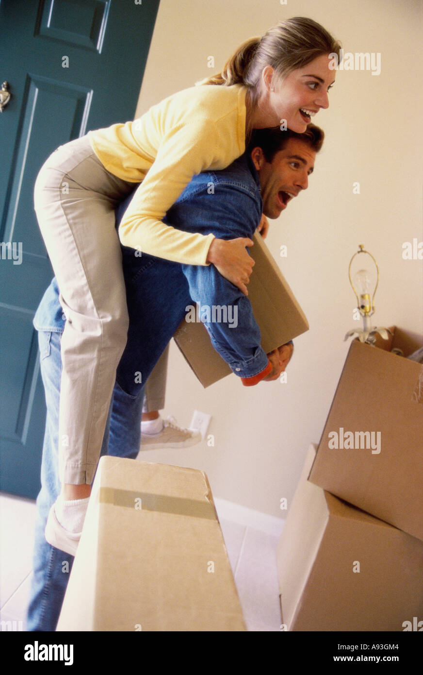 Young woman riding piggyback on a young man Stock Photo - Alamy