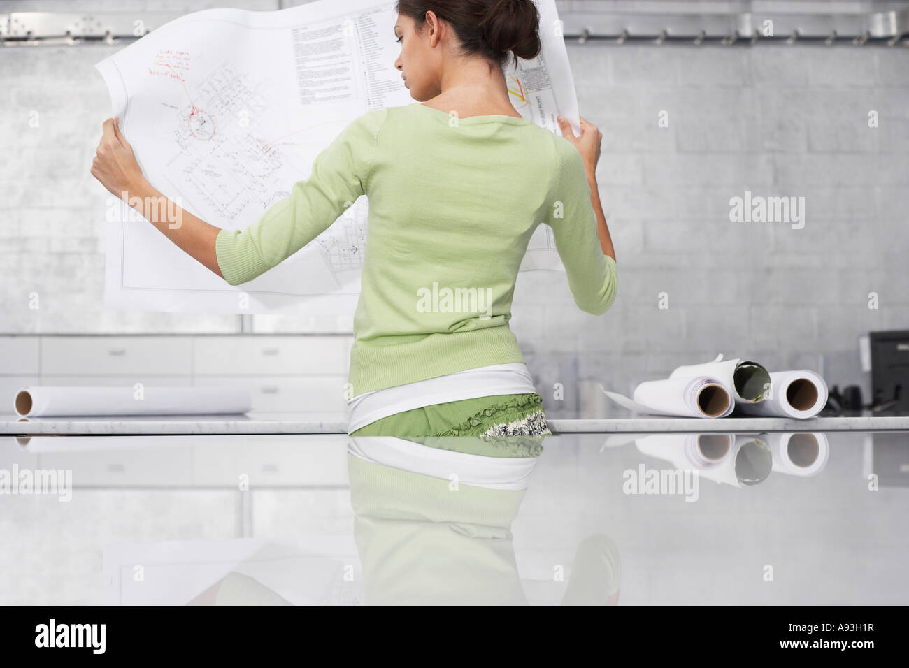 Young woman holding blueprint, back view Stock Photo - Alamy