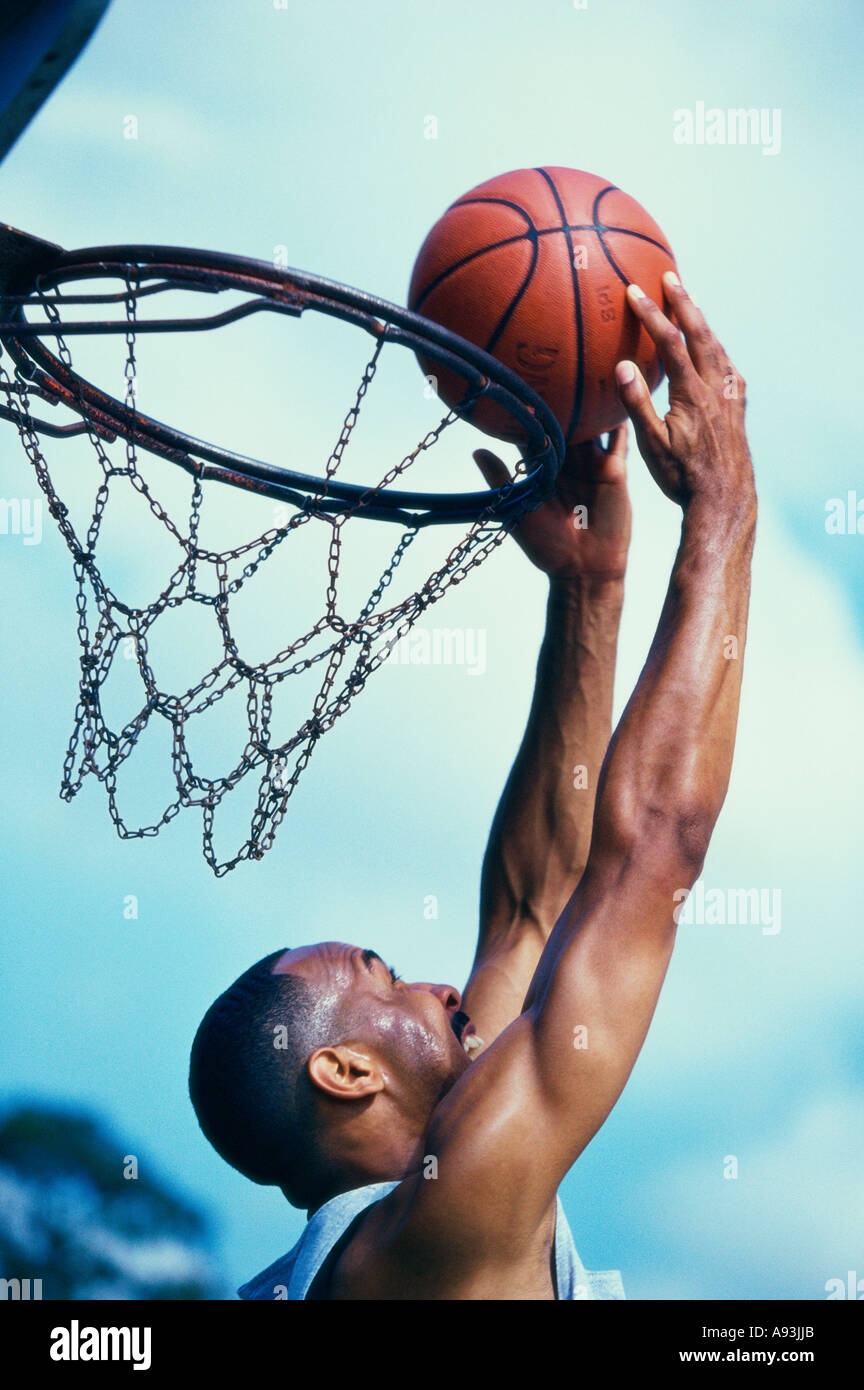 Side profile of a young man slam dunking Stock Photo - Alamy