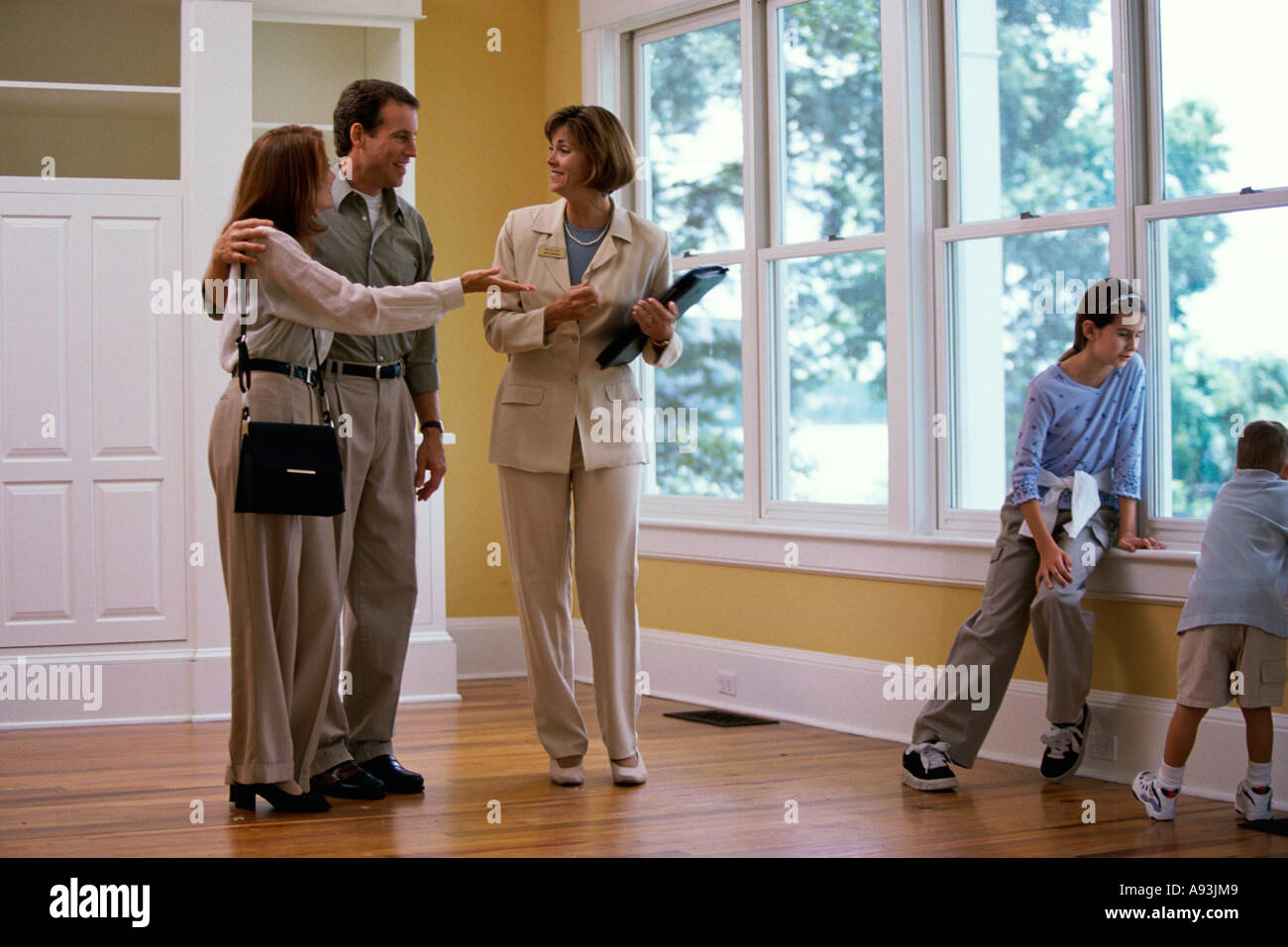 Real estate agent showing a house to a family Stock Photo - Alamy